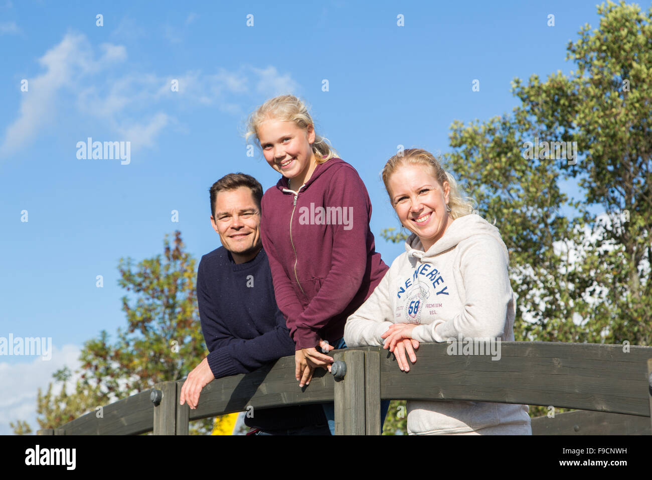 A happy family standing outdoors smiling Stock Photo - Alamy