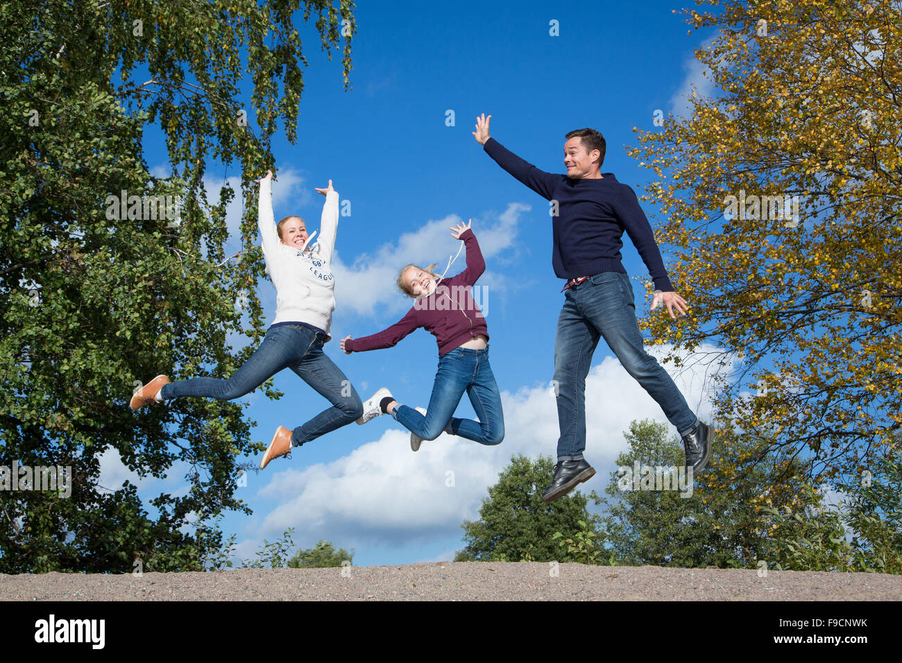 A family jumping high together raising hands up towards the sky Stock ...
