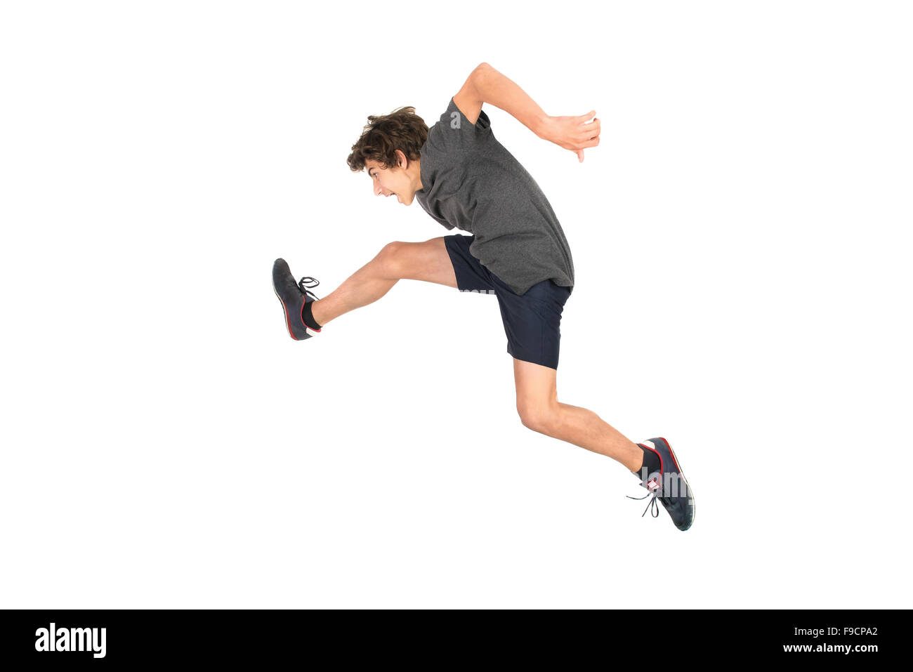 Teenage boy doing funny acrobatic jumps isolated in white Stock Photo ...