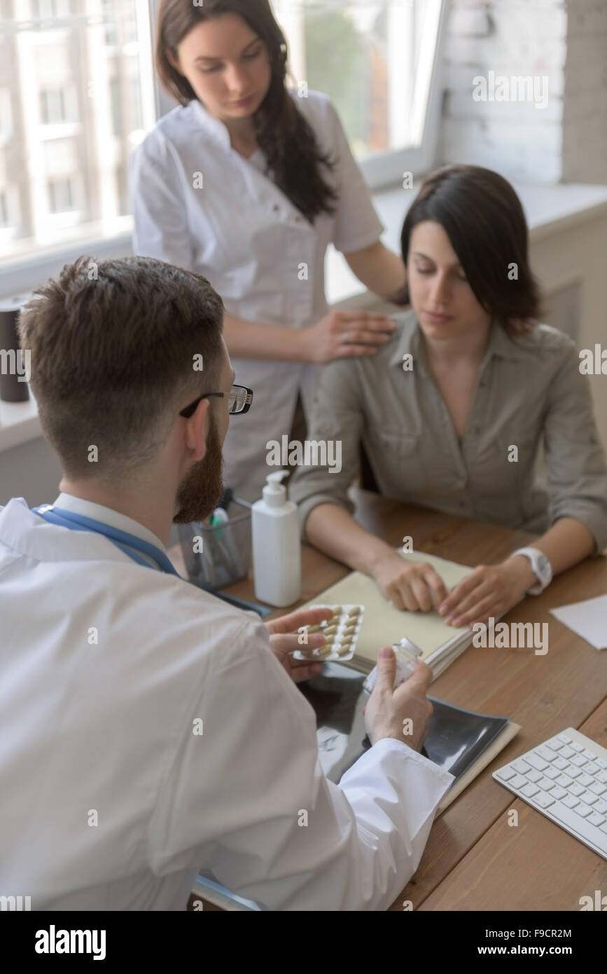 At doctor office. Doctor talking to patient after tests. Nurse standing ...