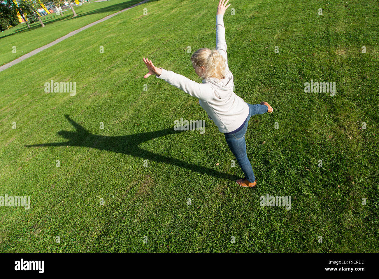 Woman making a shadow on grass Stock Photo - Alamy