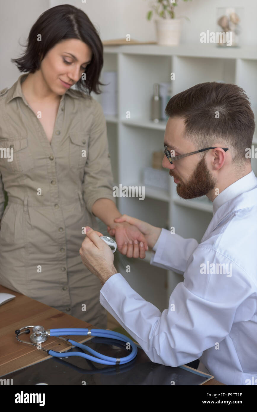 At doctor office. Doctor measuring patient pulse Stock Photo - Alamy