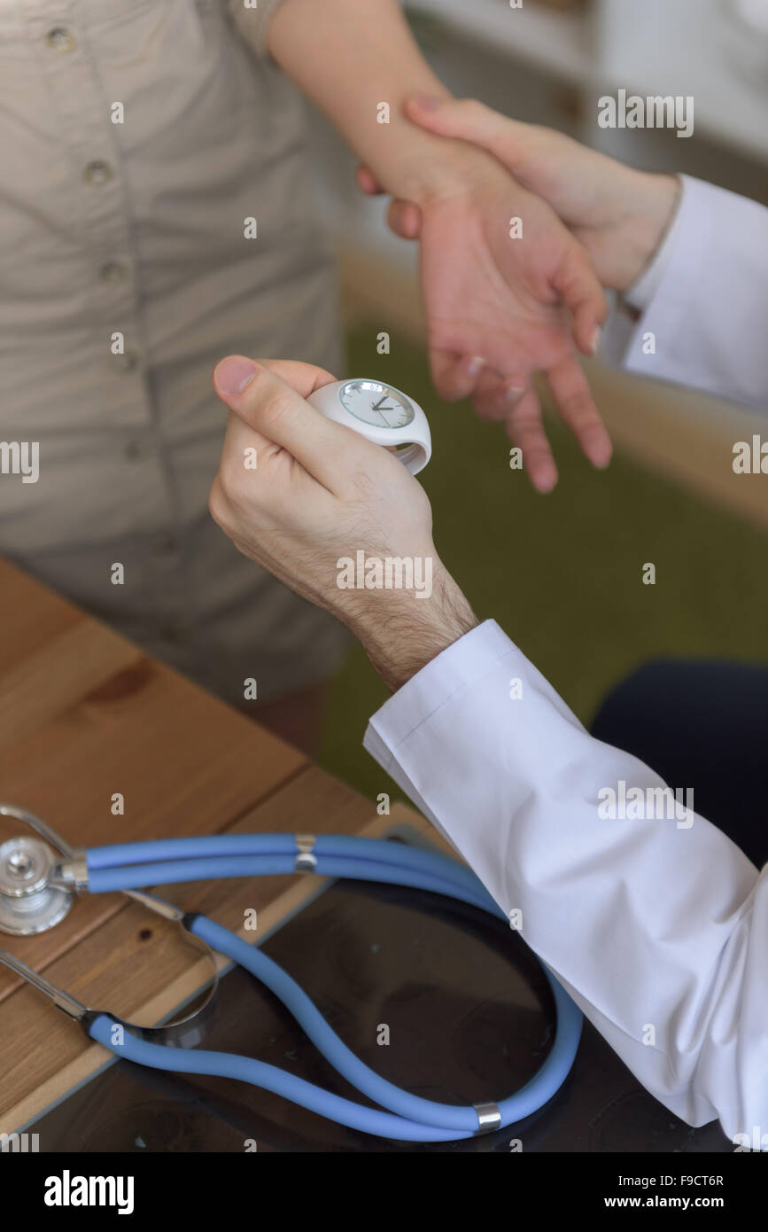 At doctor office. Doctor measuring patient pulse Stock Photo - Alamy