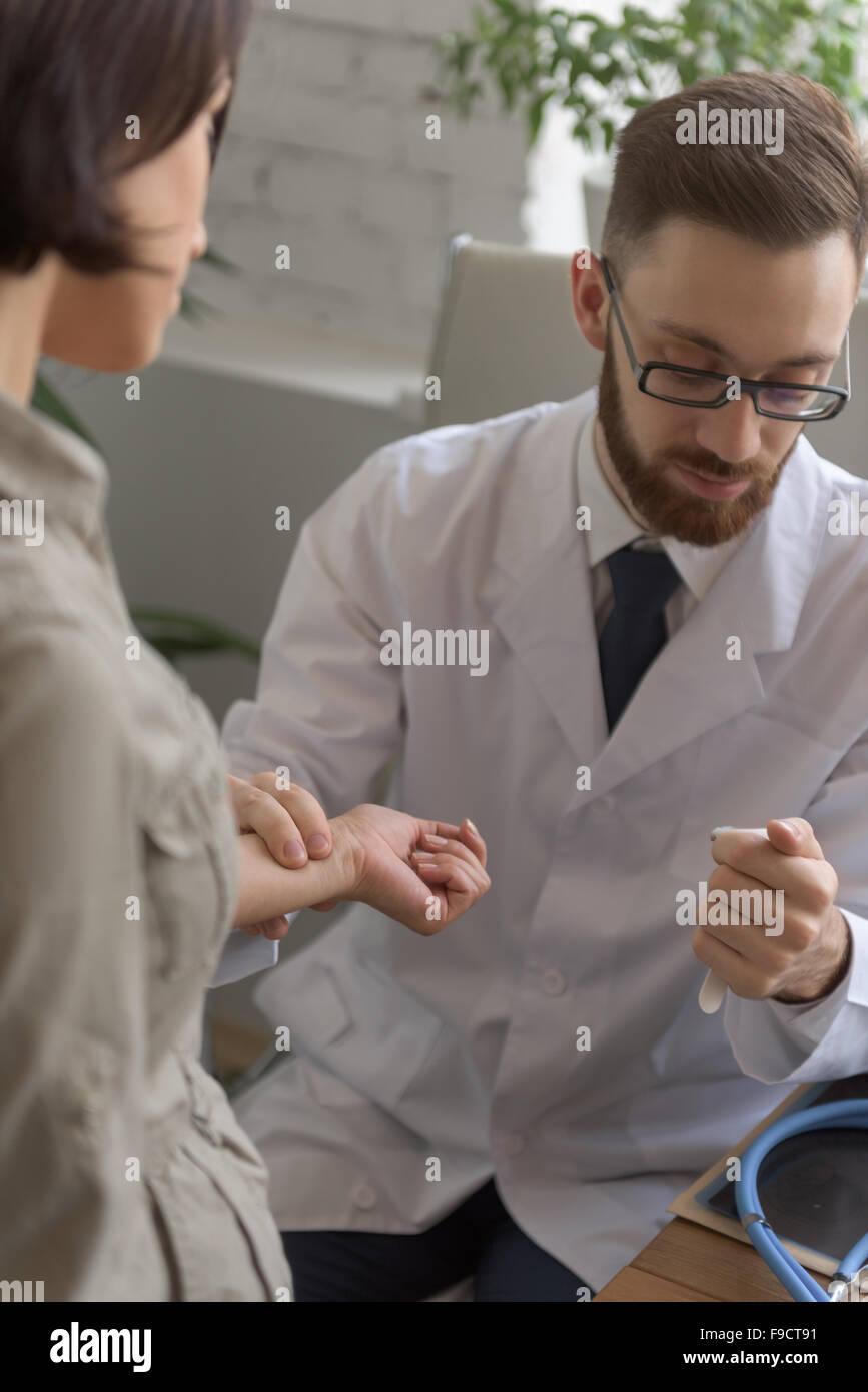 At doctor office. Doctor measuring patient pulse Stock Photo - Alamy