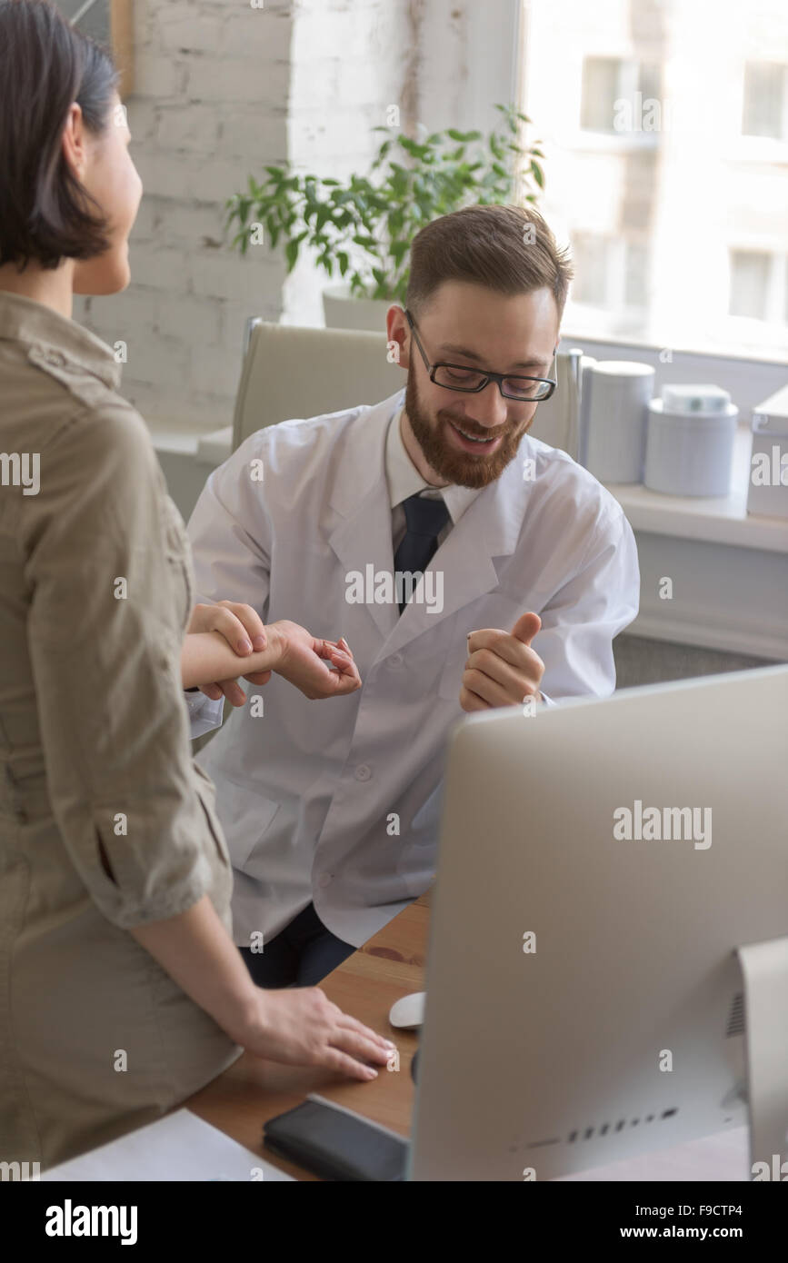 At doctor office. Doctor measuring patient pulse Stock Photo - Alamy