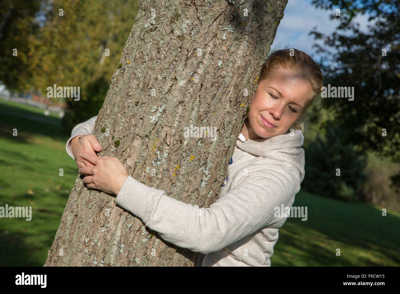 Woman hugging a tree Stock Photo - Alamy
