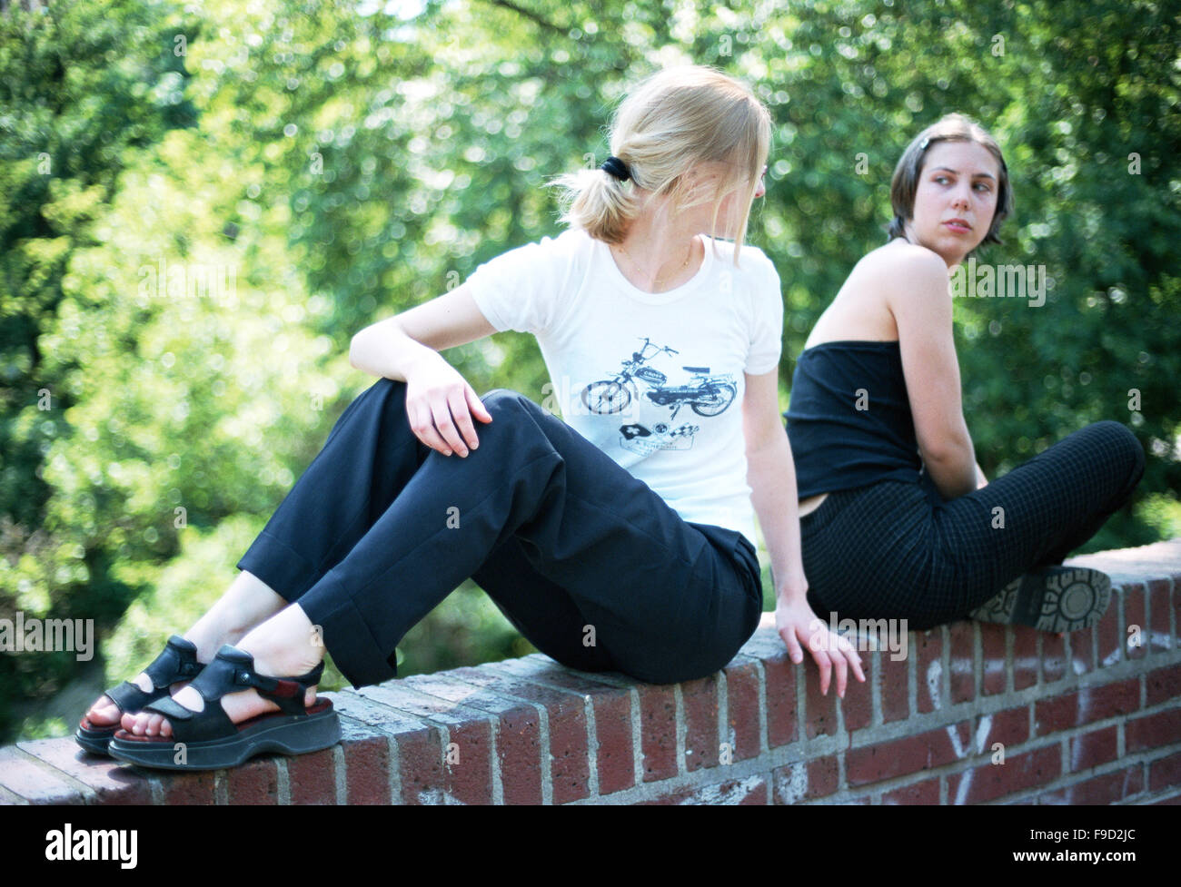 Two Girls on Wall in Dissension Stock Photo - Alamy