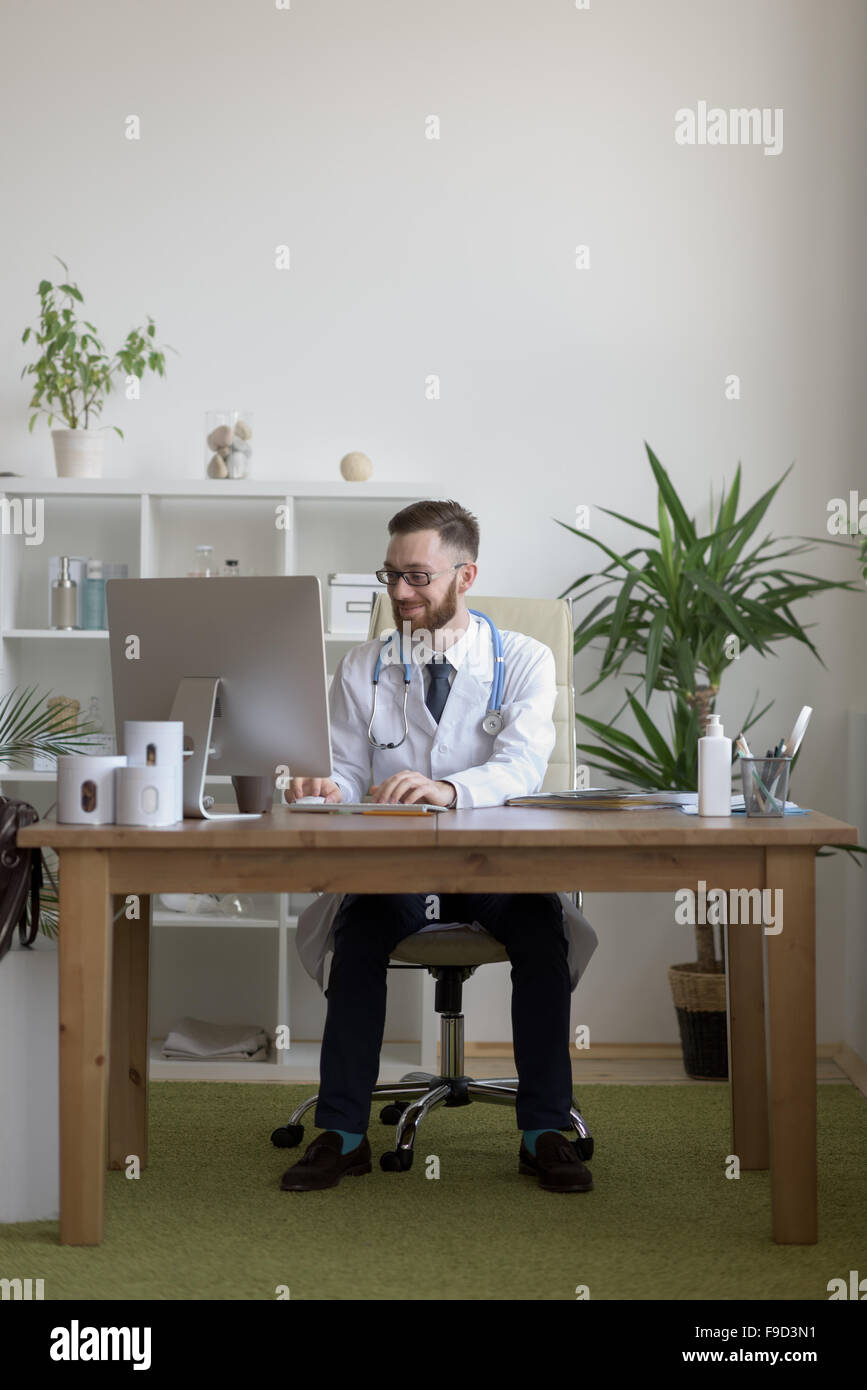 Doctor typing on his computer in the office Stock Photo - Alamy
