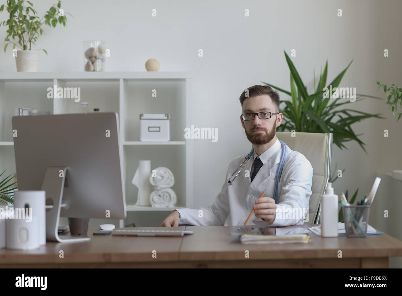 Doctor sitting relaxed in his chair in the office Stock Photo - Alamy