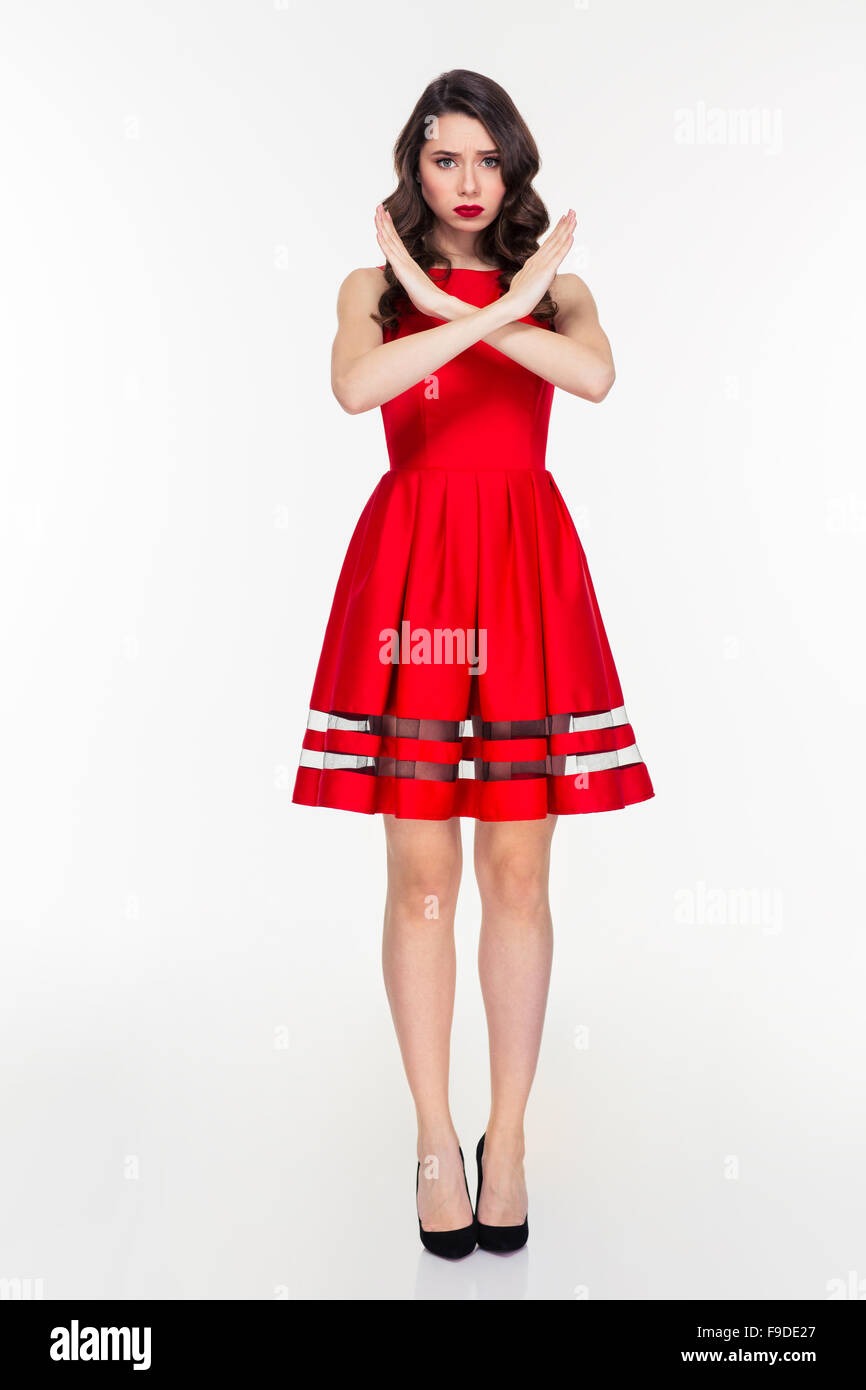 Full length portrait of a young woman in red dress showing stop sign ...