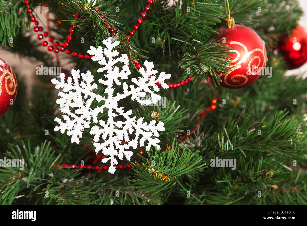 White snowflake on a Christmas tree with red balls Stock Photo - Alamy