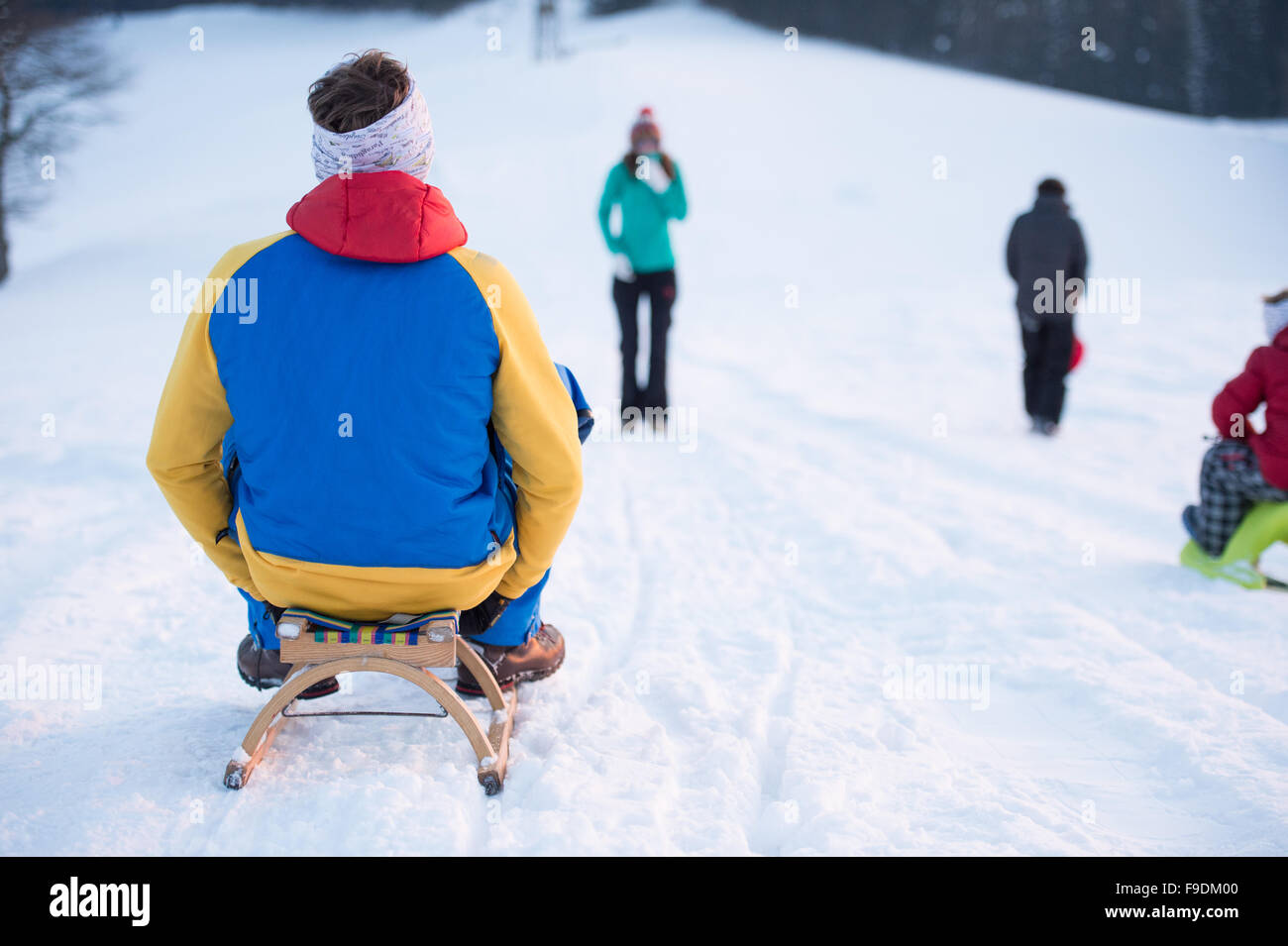 Young family sledging in winter Stock Photo - Alamy