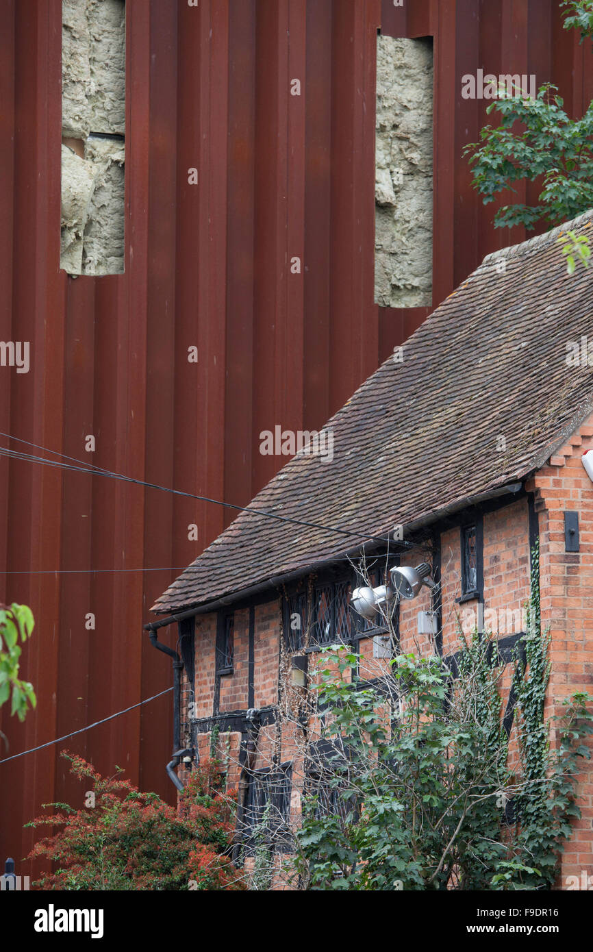 A historic timber framed house overshadowed by an unsightly factory ...