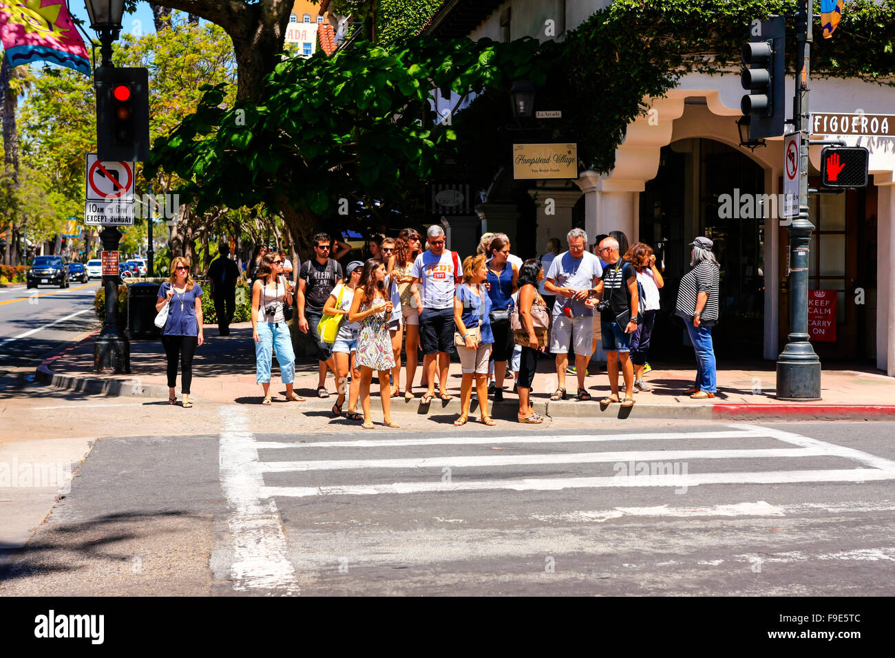 People at a pedestrian crossing waiting for the lights to change so ...