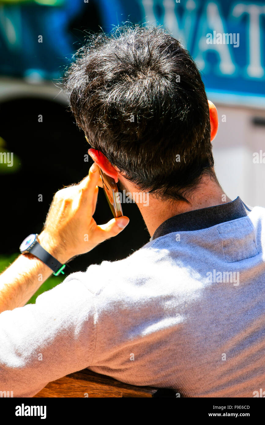 Back view of a man talking on his cell phone in downtown Santa Barbara ...