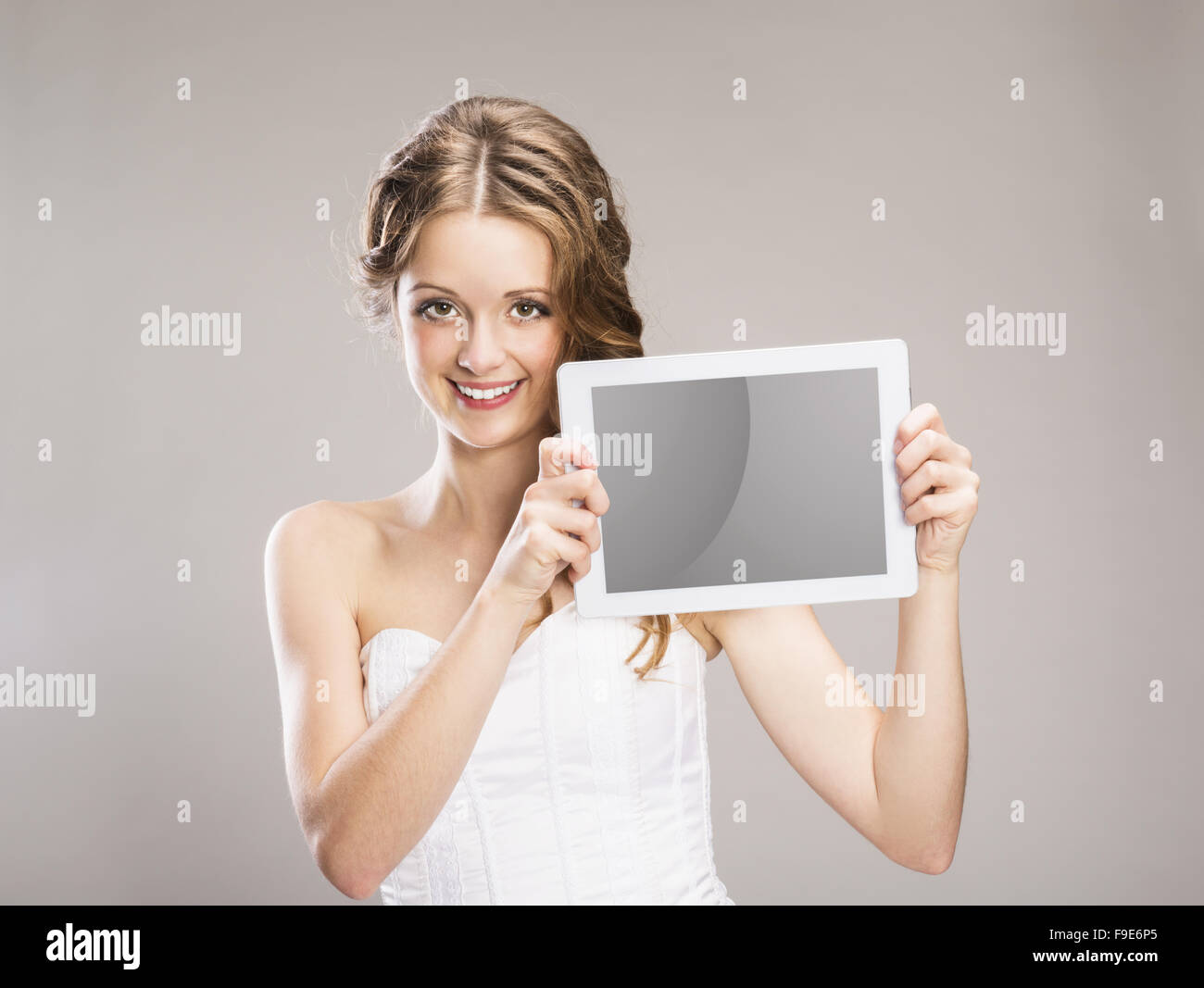 Studio portraits of beautiful bride with digital tablet isolated on ...