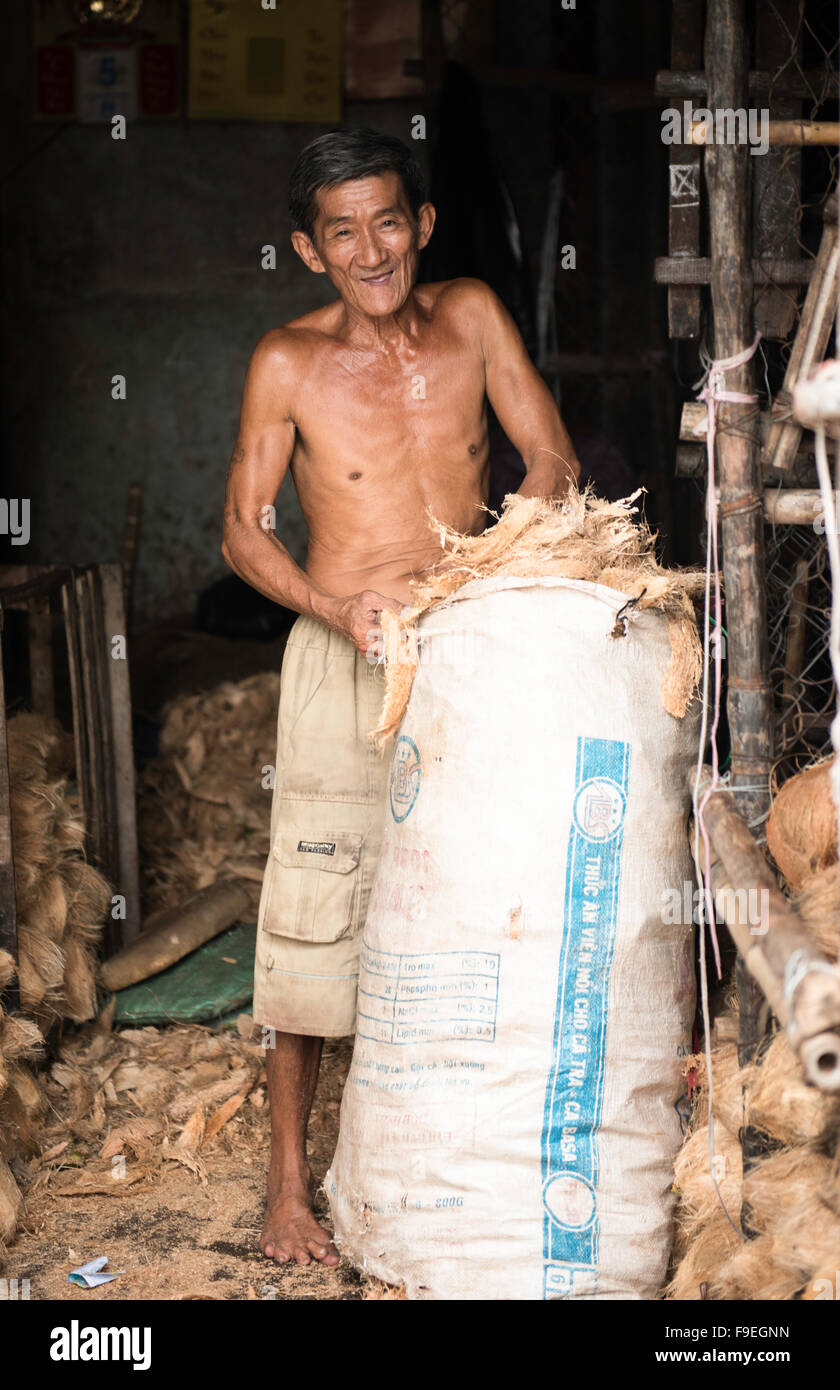 An elderly man packs coconut coir into sacks Stock Photo - Alamy