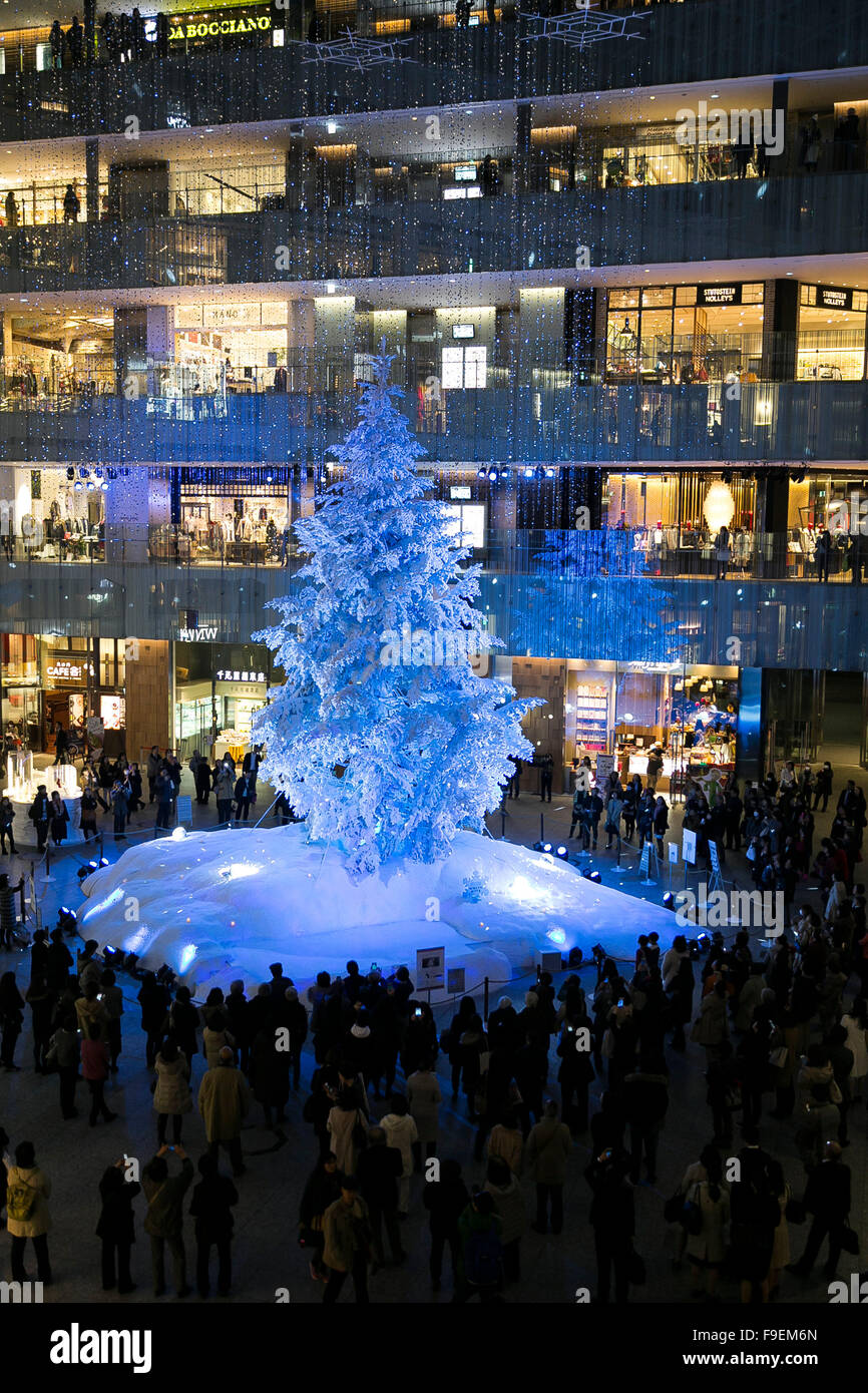 Visitors look at a 14.5m height snow covered Christmas Tree on display ...