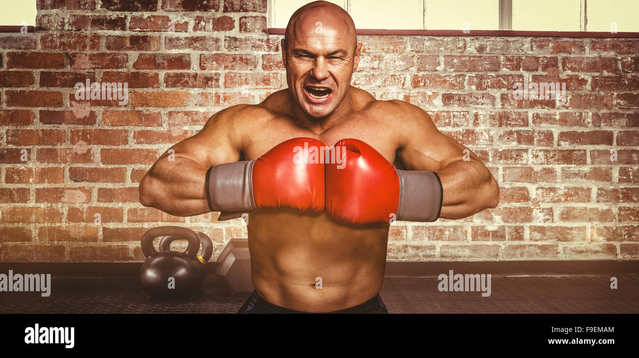 Composite image of angry bald boxer with punching gloves Stock Photo ...