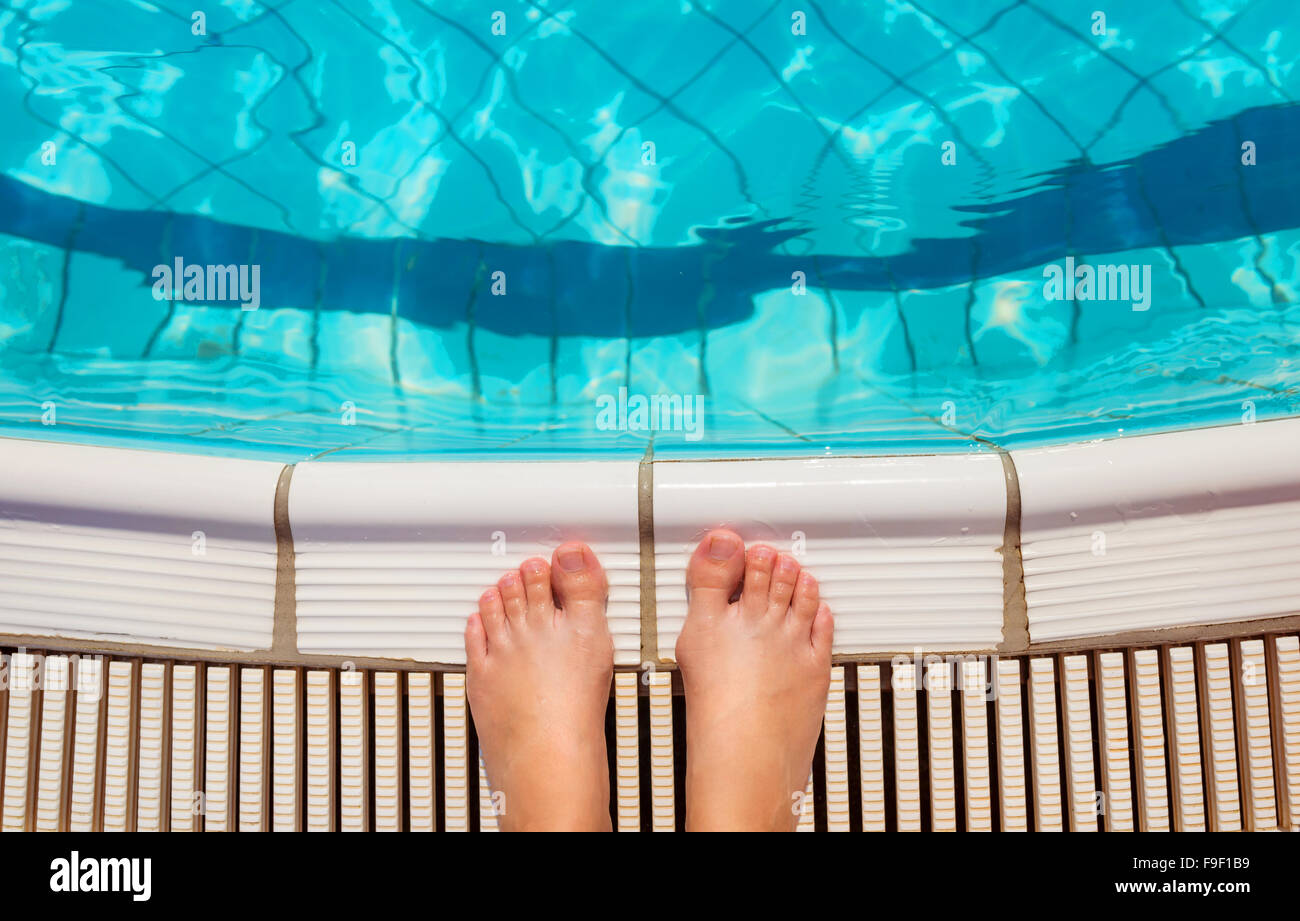 Feet of a young woman standing at the swimming pool Stock Photo - Alamy