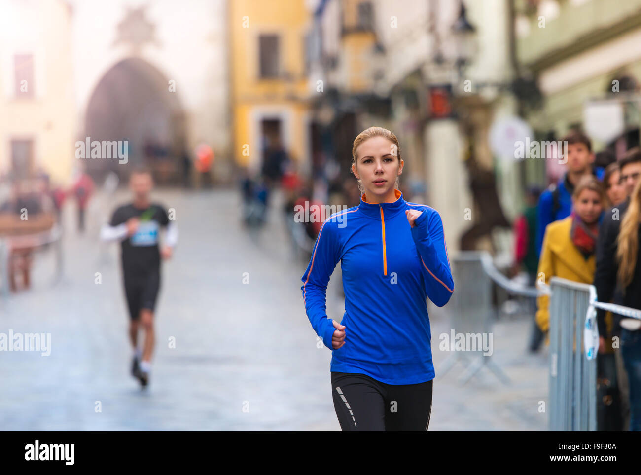 Beautiful young woman running in the city competition Stock Photo - Alamy