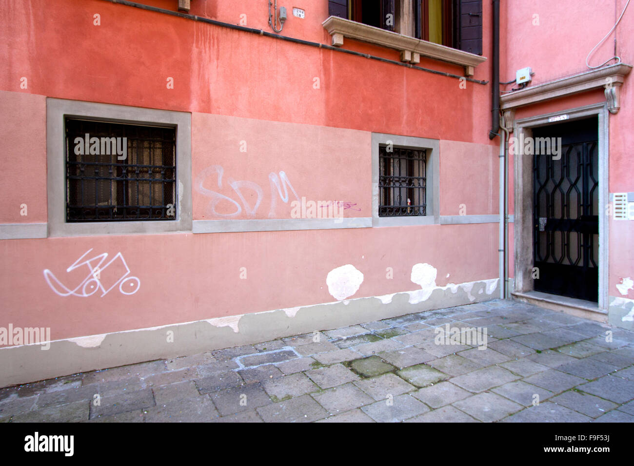 Two windows and a door on a pink building Stock Photo - Alamy
