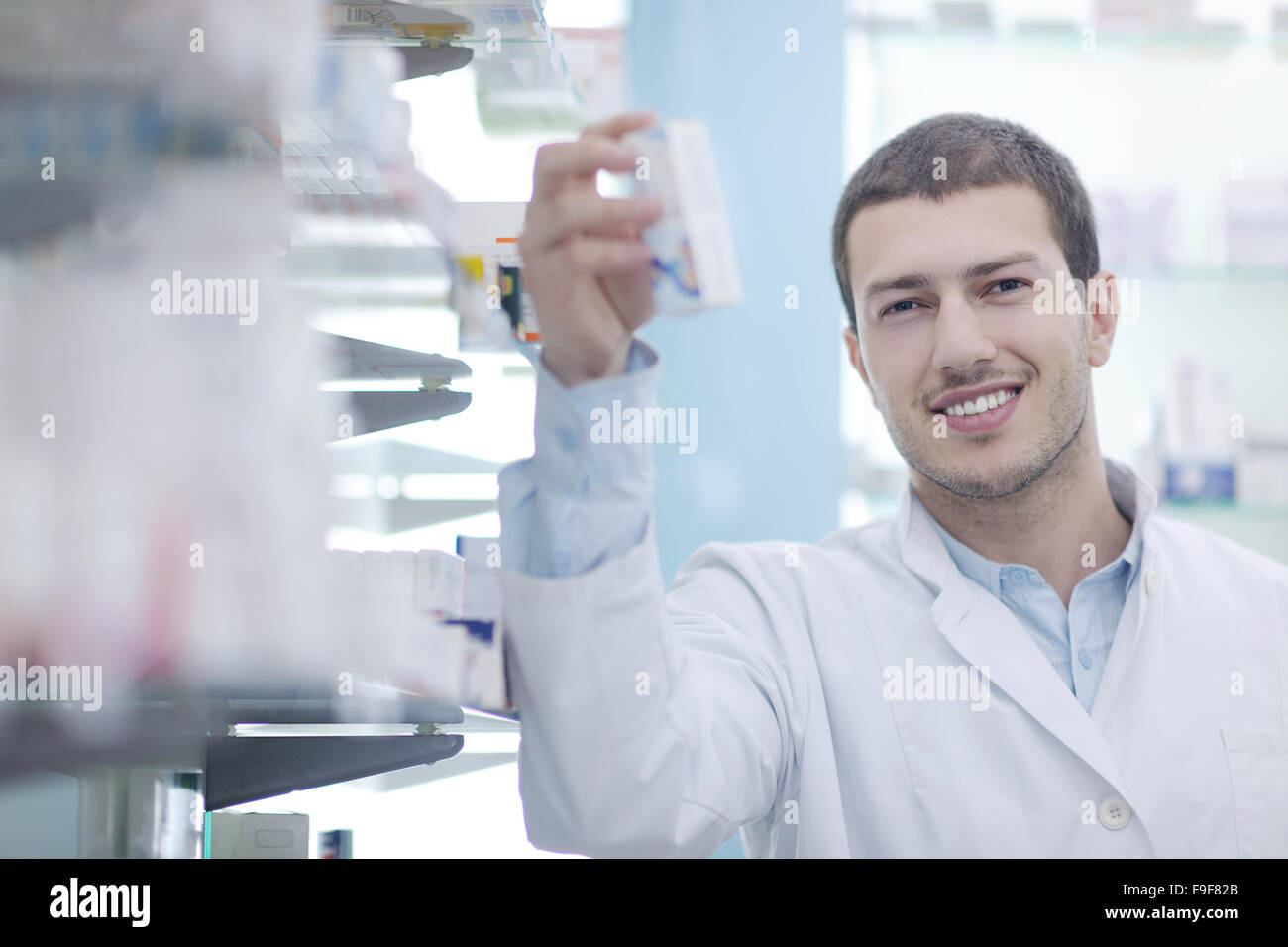 portrait of handsome young pharmacist chemist man standing in pharmacy ...