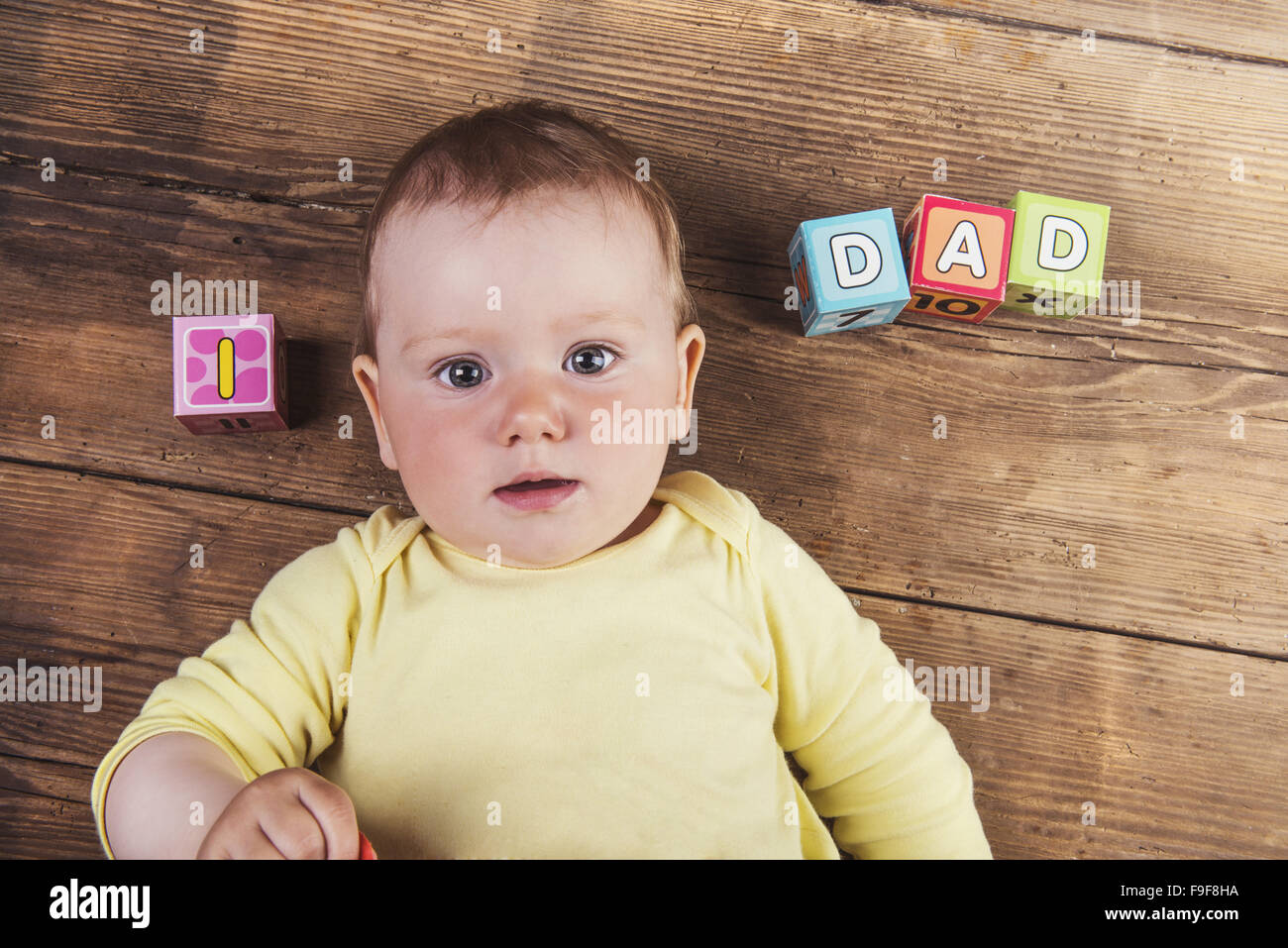 Little baby with cubes with dad sign on wooden background Stock Photo ...