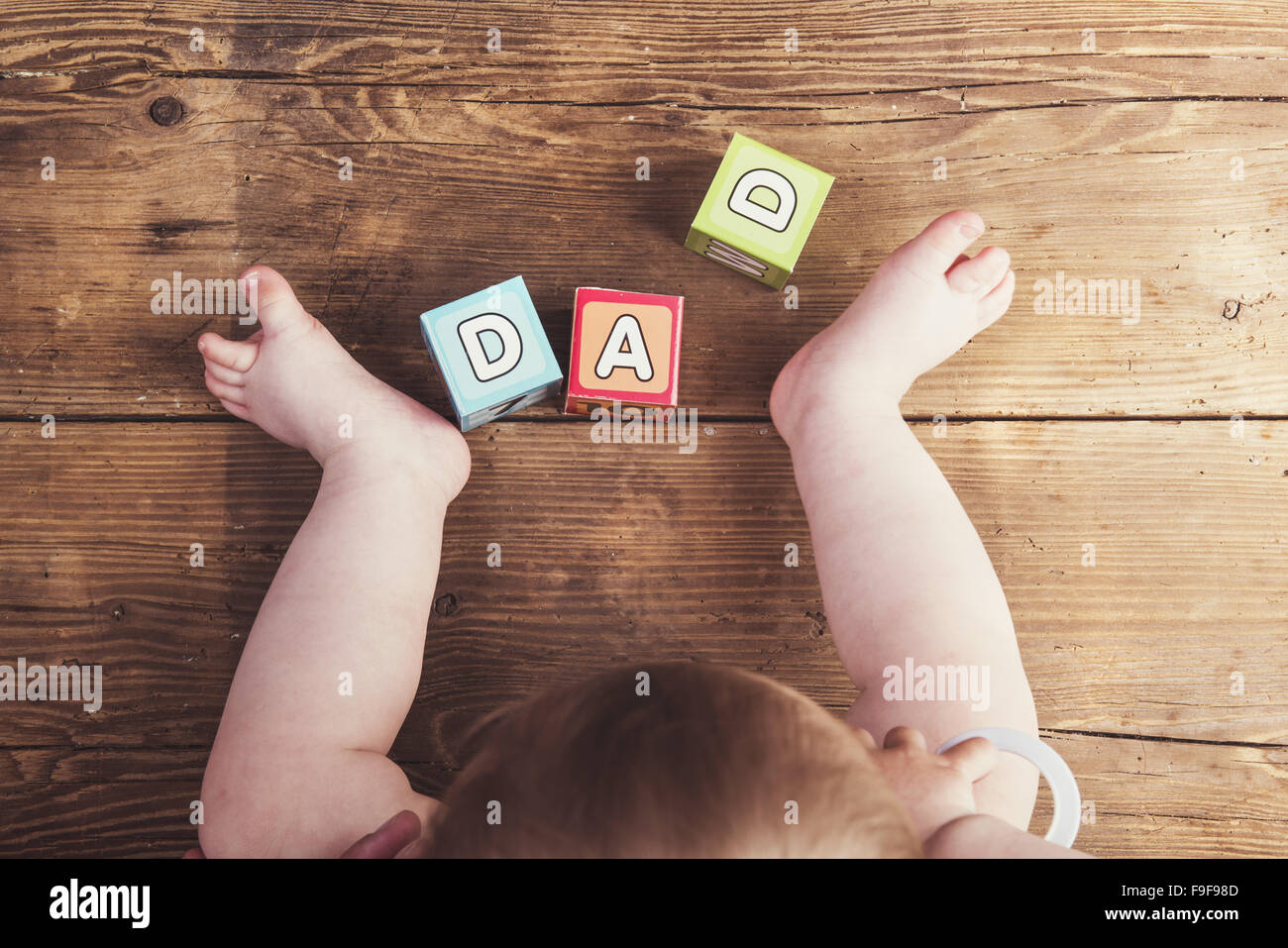 Little baby with cubes with dad sign on wooden background Stock Photo ...