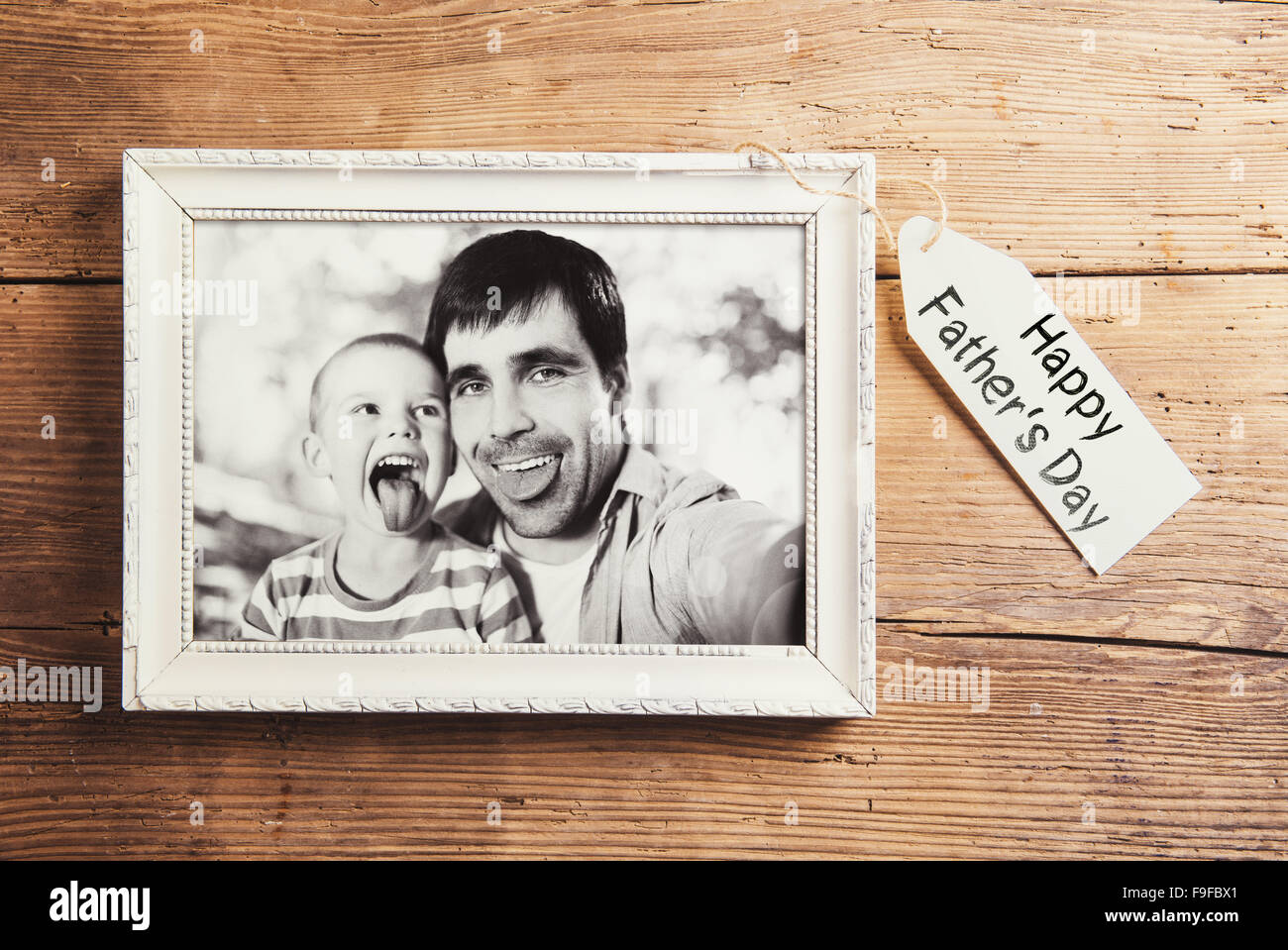 Family photo in white picture frame. Studio shot on wooden backgroung ...