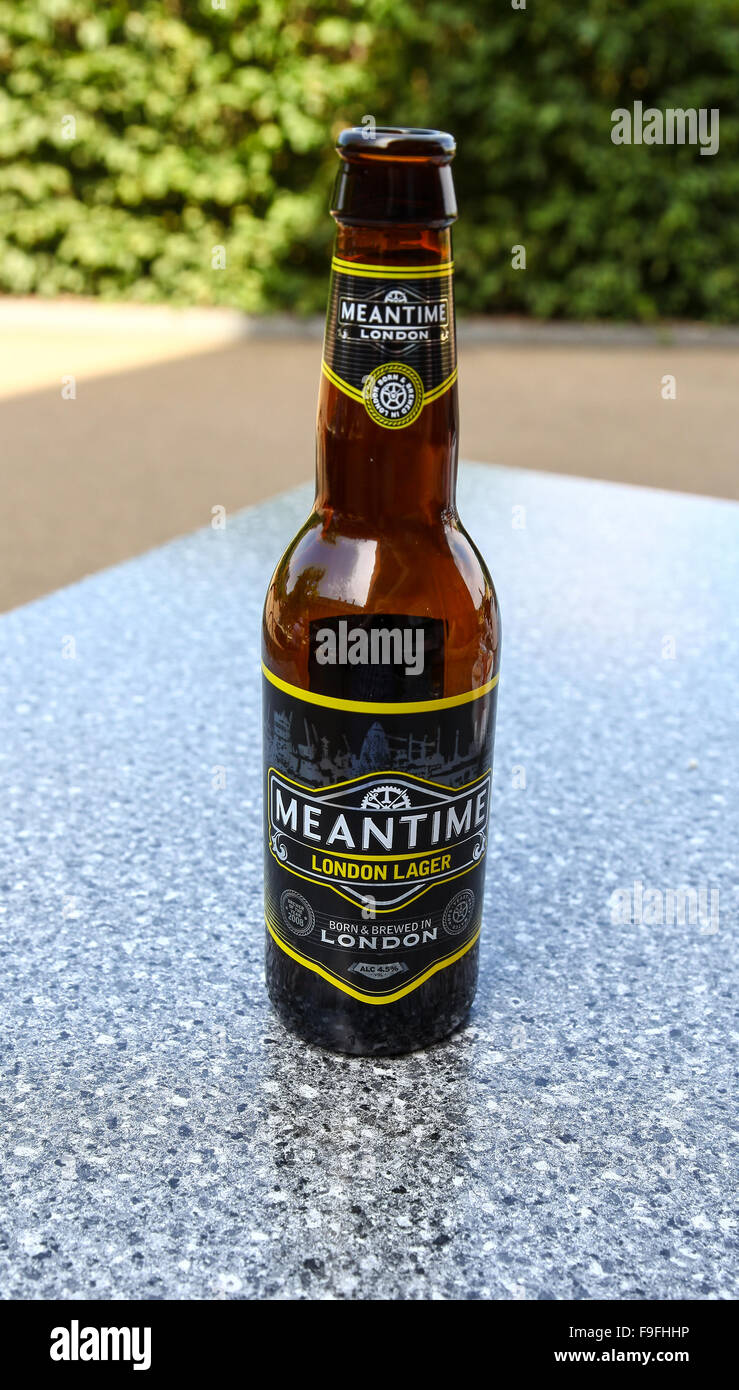A glass bottle of Meantime London lager sitting on a table outdoors ...
