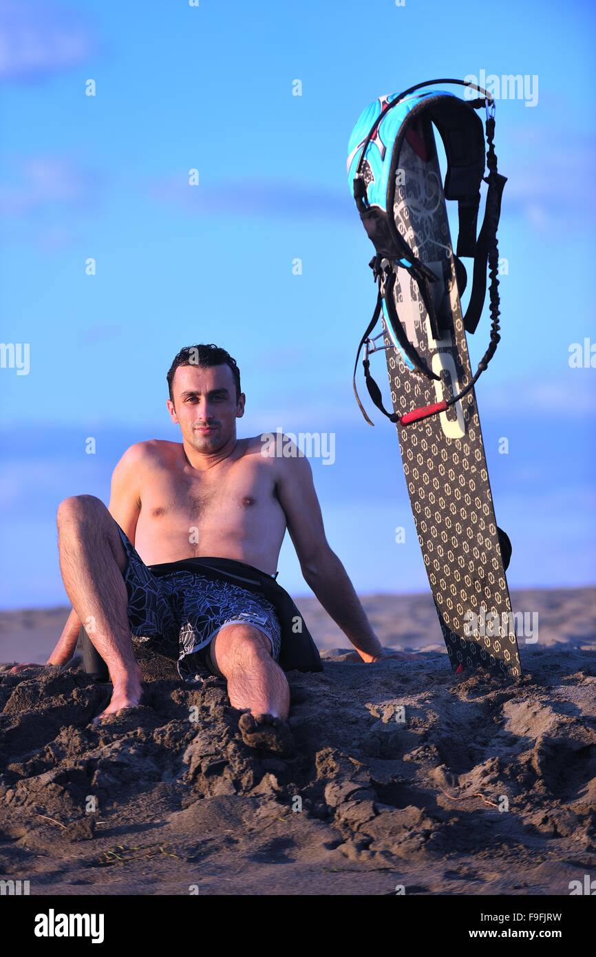 Portrait of a strong young surf man at beach on sunset in a ...