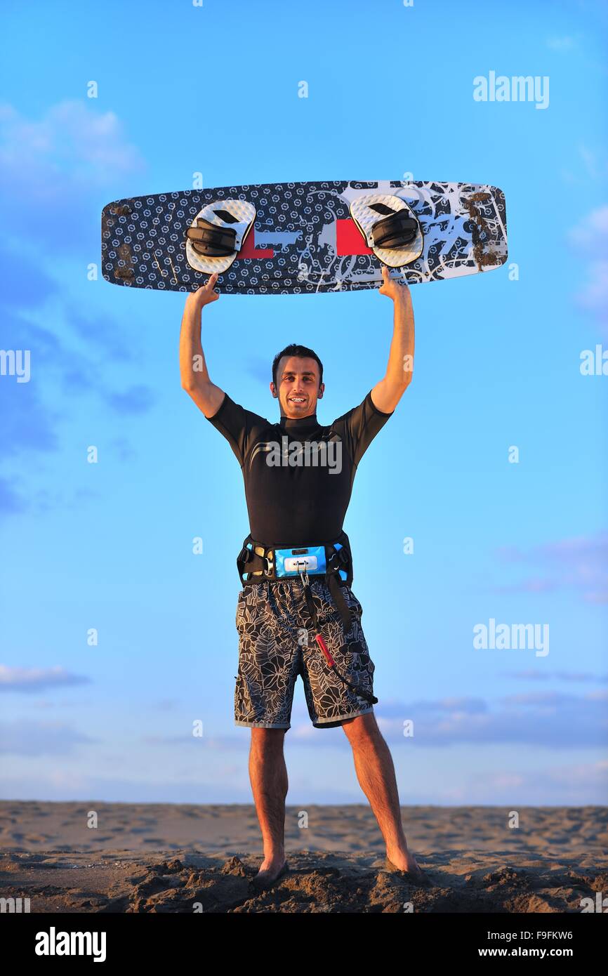 Portrait of a strong young surf man at beach on sunset in a ...