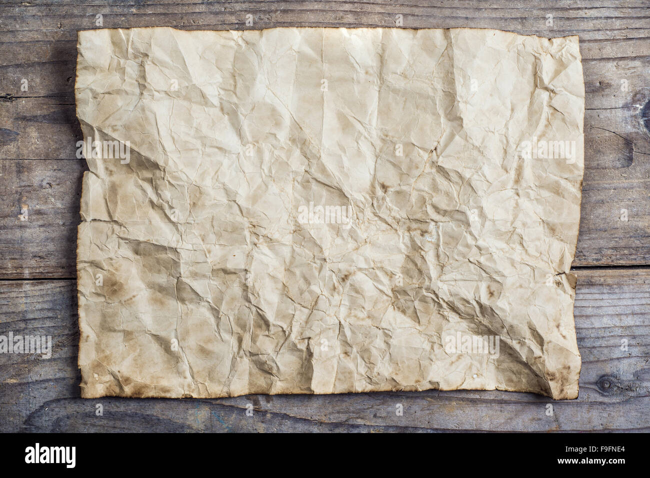 Piece of old rumpled paper on wooden floor background Stock Photo - Alamy