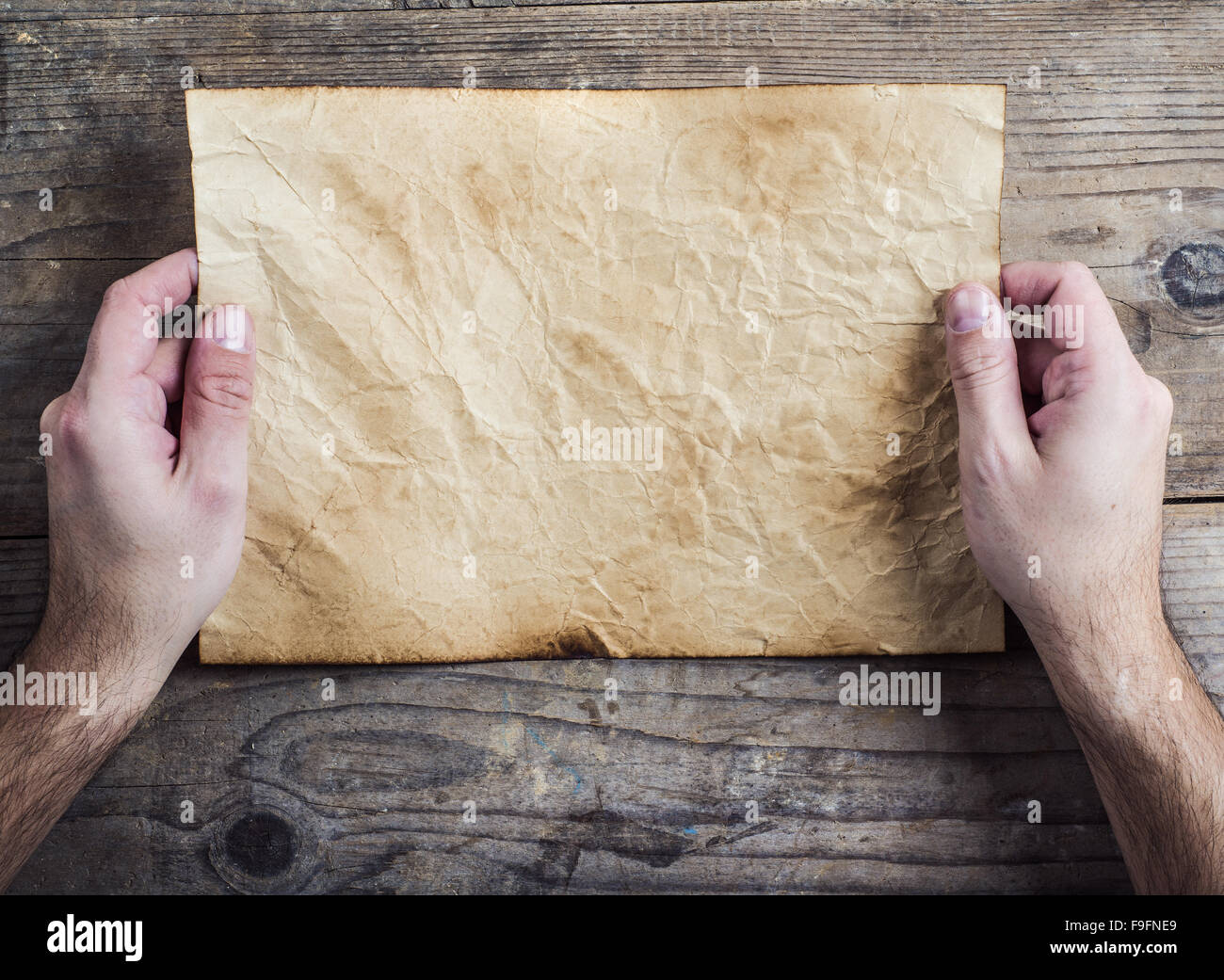 Piece of old rumpled paper on wooden floor background Stock Photo - Alamy