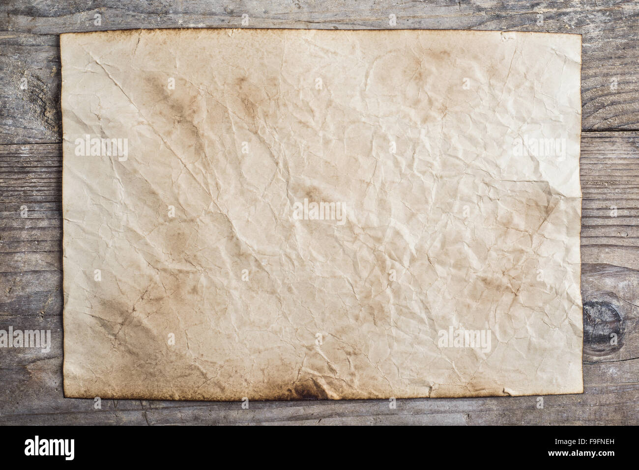 Piece of old rumpled paper on wooden floor background Stock Photo - Alamy
