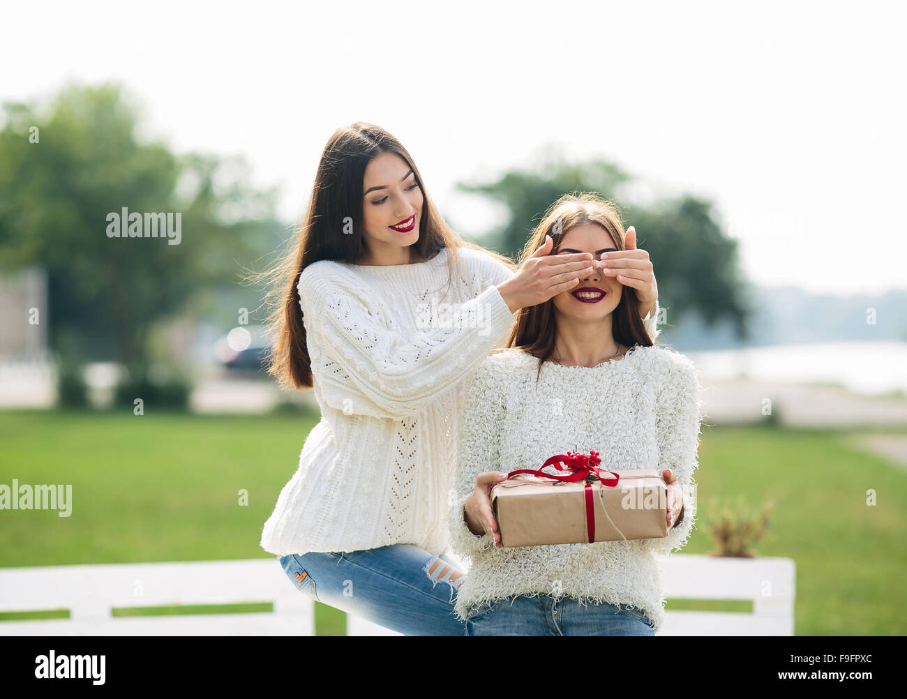 Two beautiful girls and gift Stock Photo - Alamy