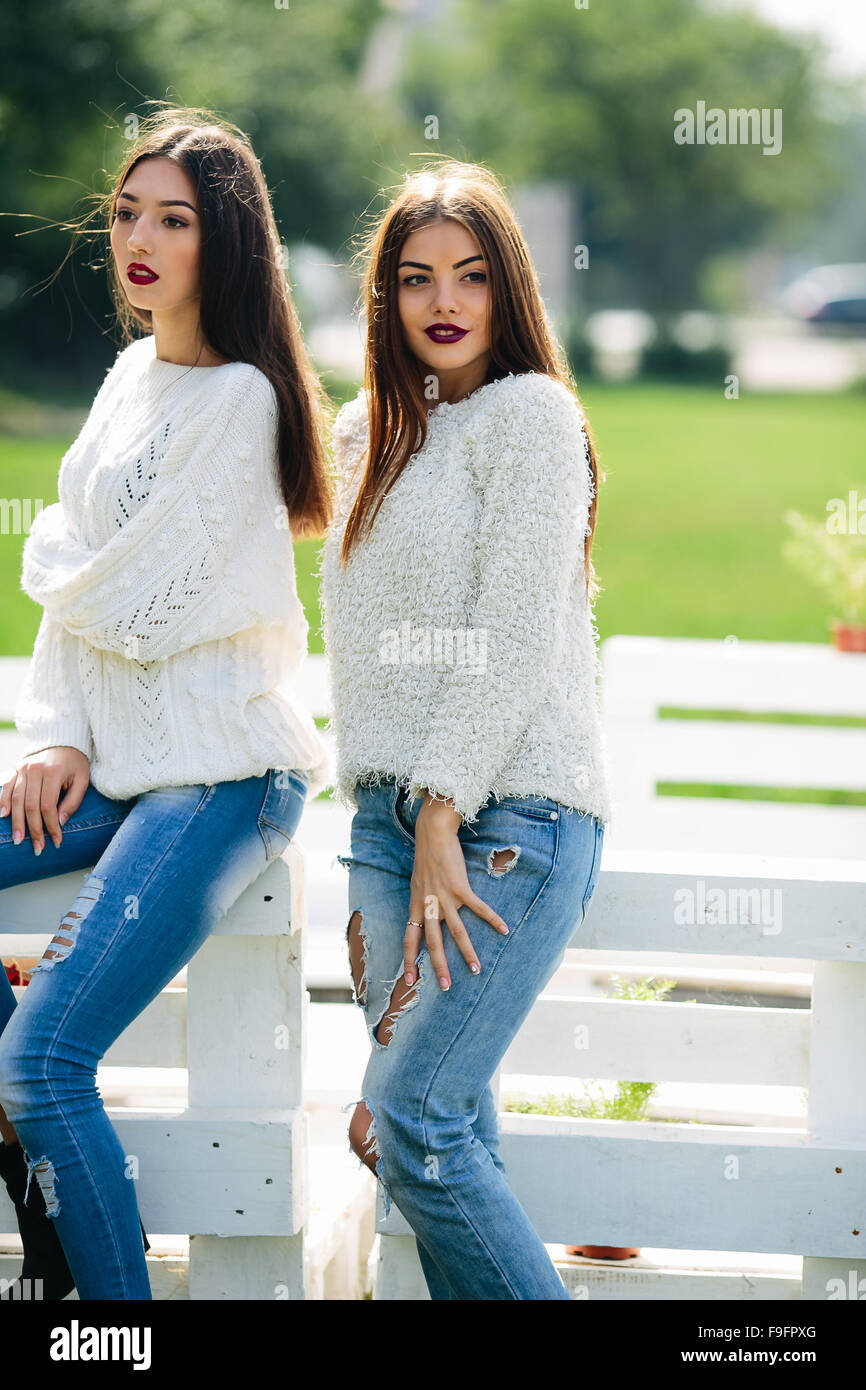 Two girls lean bench Stock Photo - Alamy
