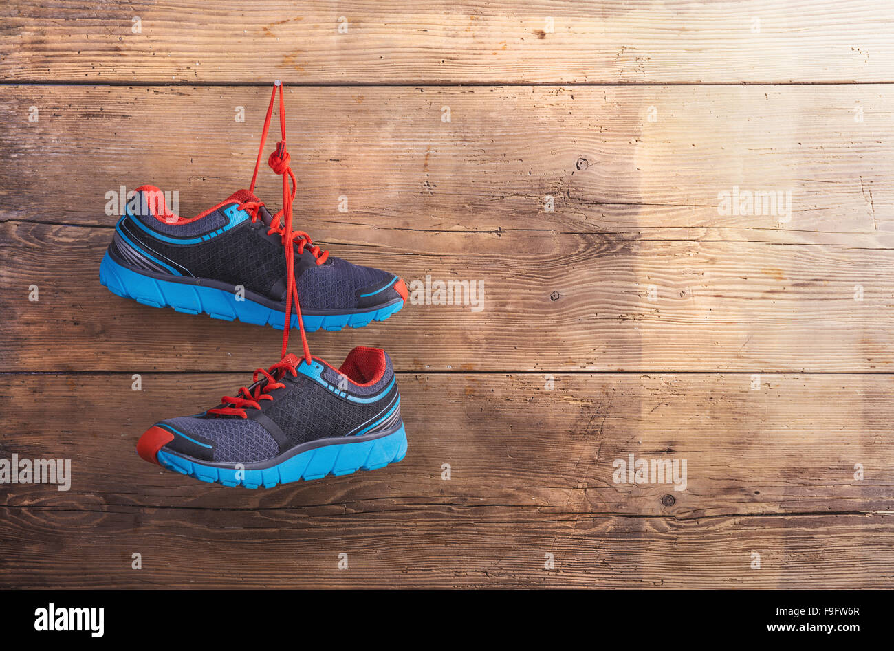 Pair of sneakers hang on a nail on a wooden fence background Stock ...