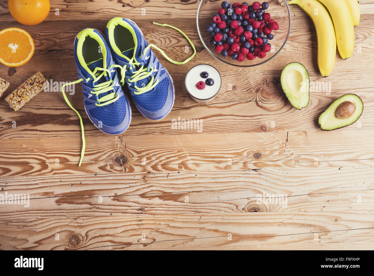Pair of running shoes and healthy food composition on a wooden table ...