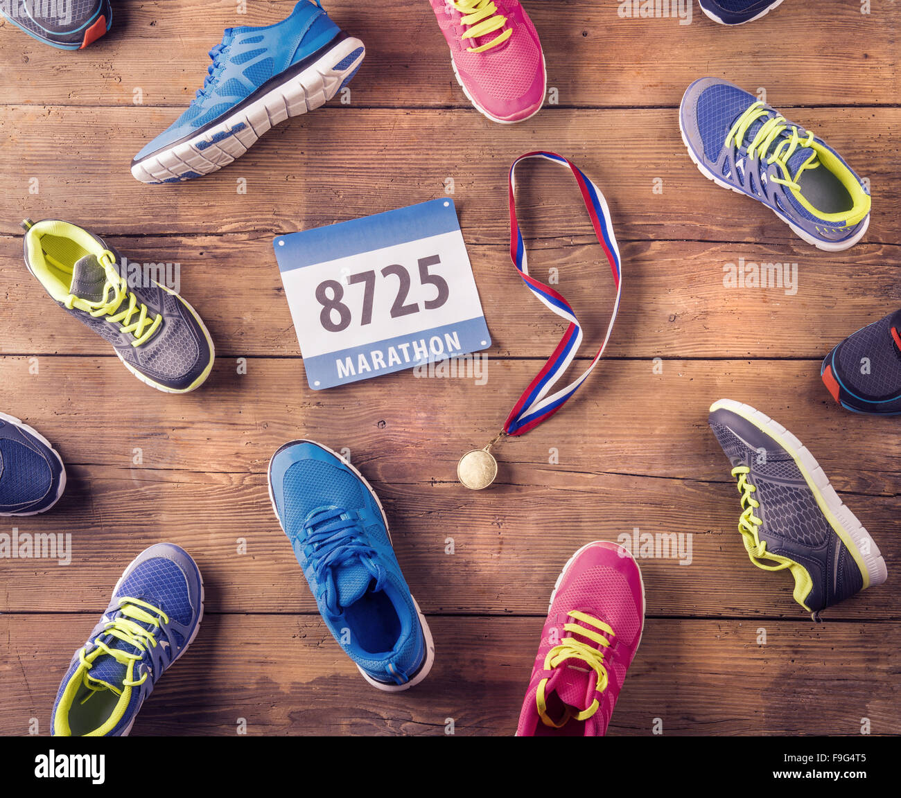 Various running shoes laid on a wooden floor background Stock Photo - Alamy
