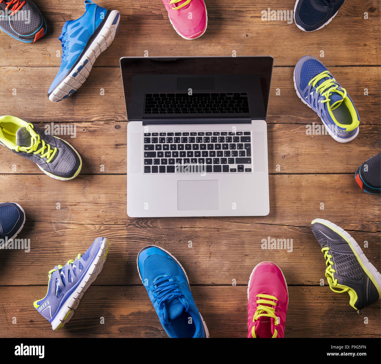 Various running shoes and notebook laid on a wooden floor background ...