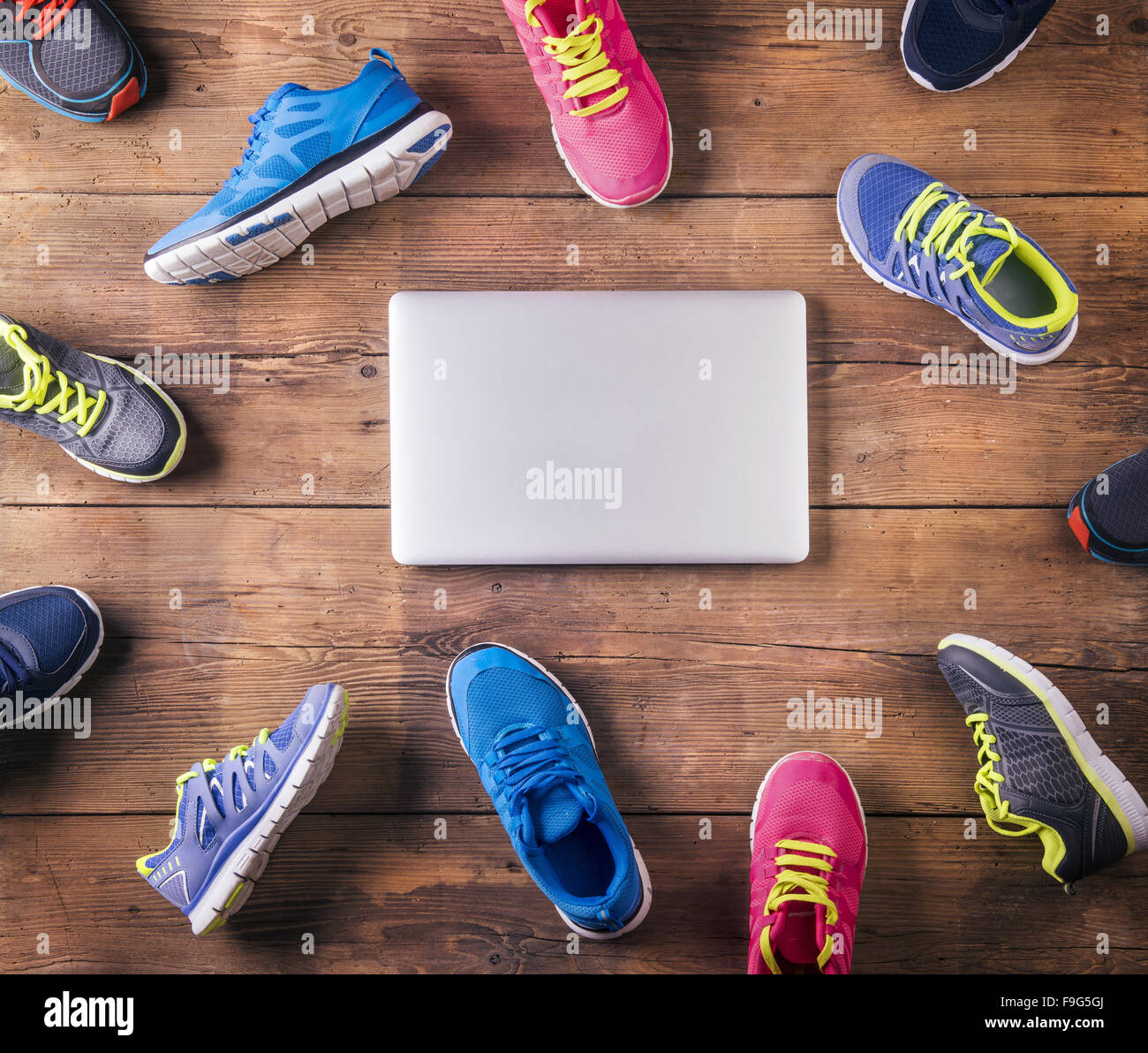 Various running shoes and notebook laid on a wooden floor background ...