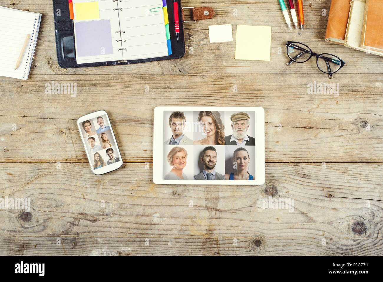 Mix of office supplies and gadgets on a wooden desk background. View ...