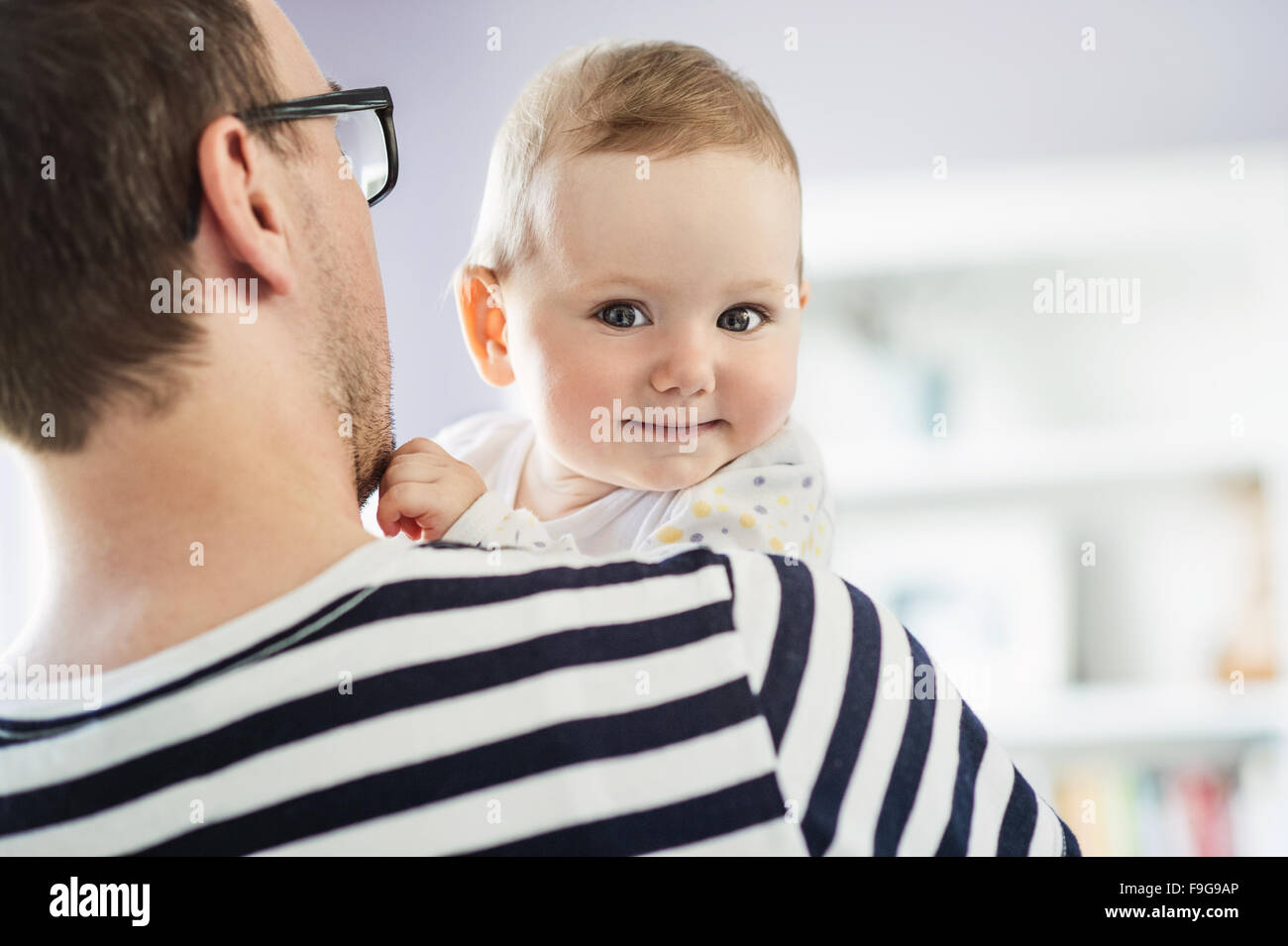 Young daddy holding his daughter in his arms Stock Photo - Alamy