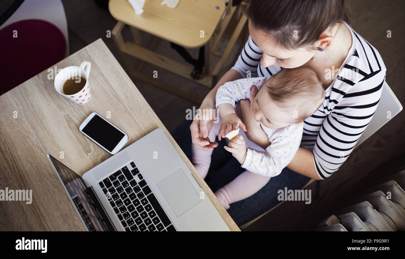 Young mother in home office with computer and her daughter Stock Photo ...