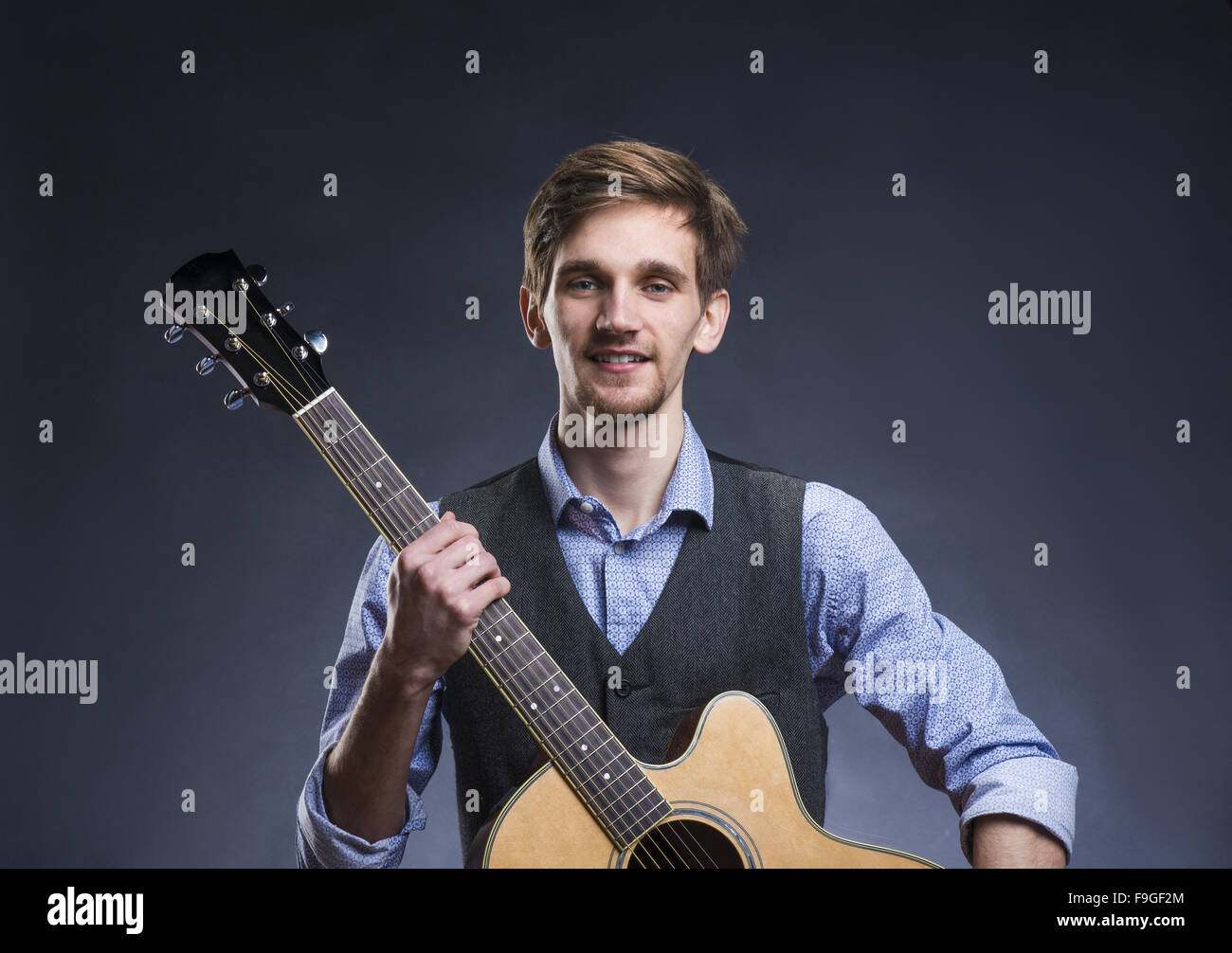 Young handsome guitar player. Studio shot on black background Stock ...