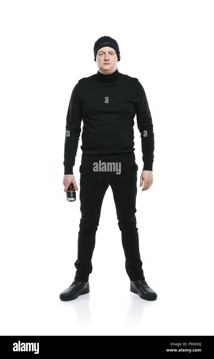 Thief in action with balaclava on his face, dressed in black. Studio ...