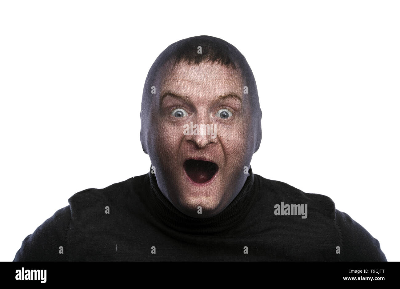 Thief in balaclava making funny faces, dressed in black. Studio shot on ...