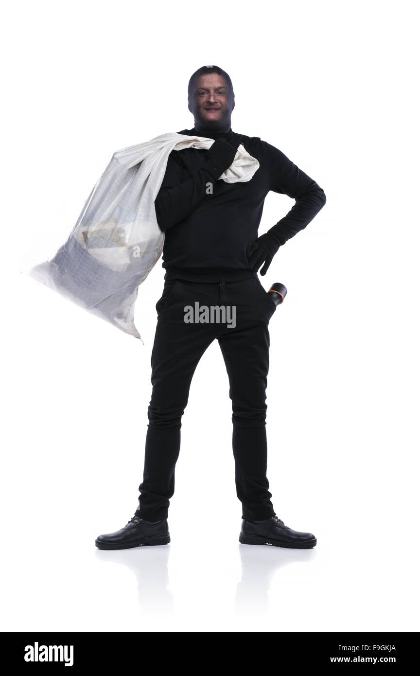 Thief in action carrying a big bag with balaclava on his face, dressed ...